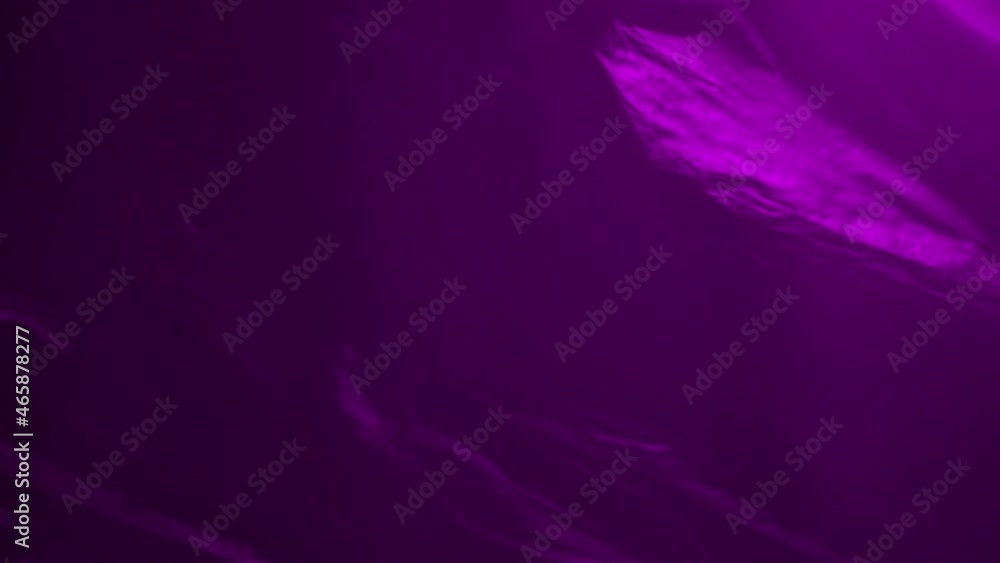 waving crumpled plastic texture with a purple neon light texture ...