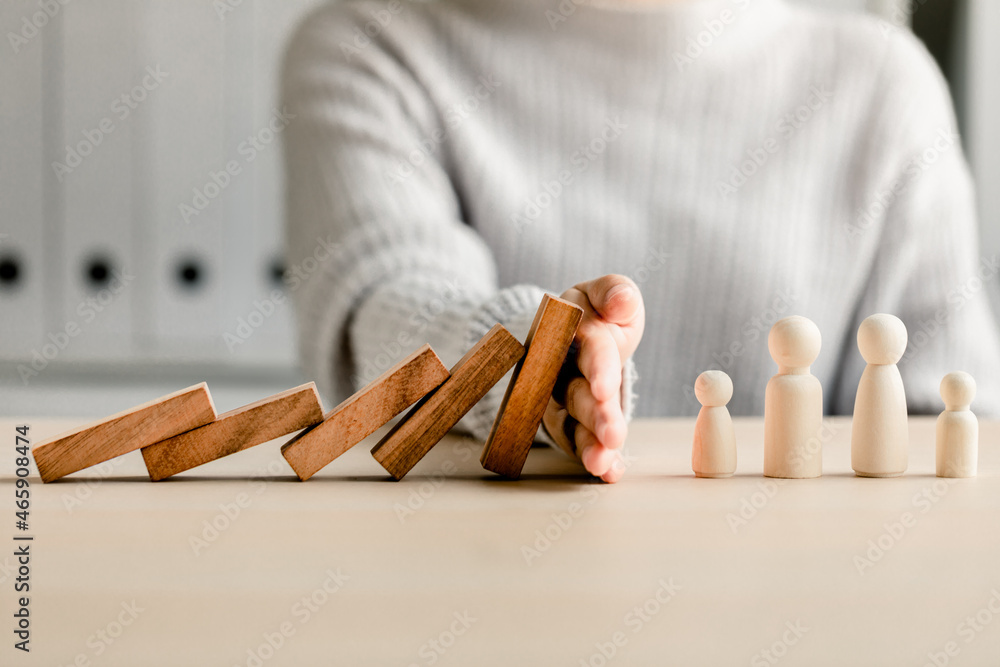 Women's hand stopping falling collapse wooden block dominoes effect ...