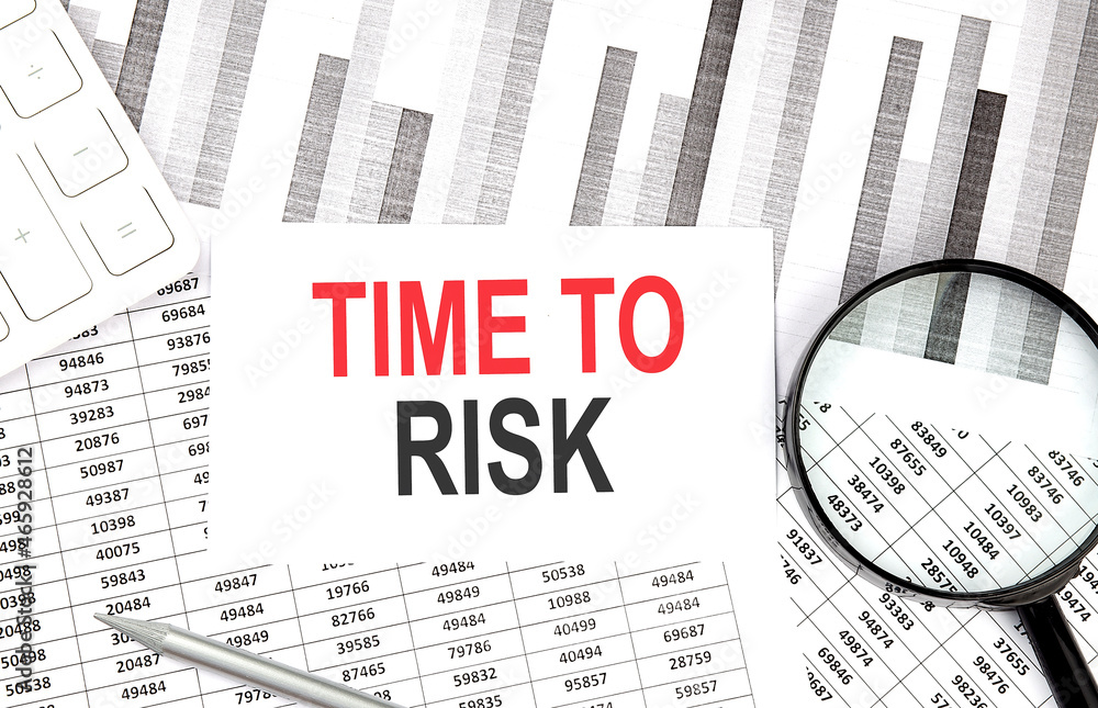 TIME TO RISK text on paper with calculator,magnifier ,pen on the graph ...