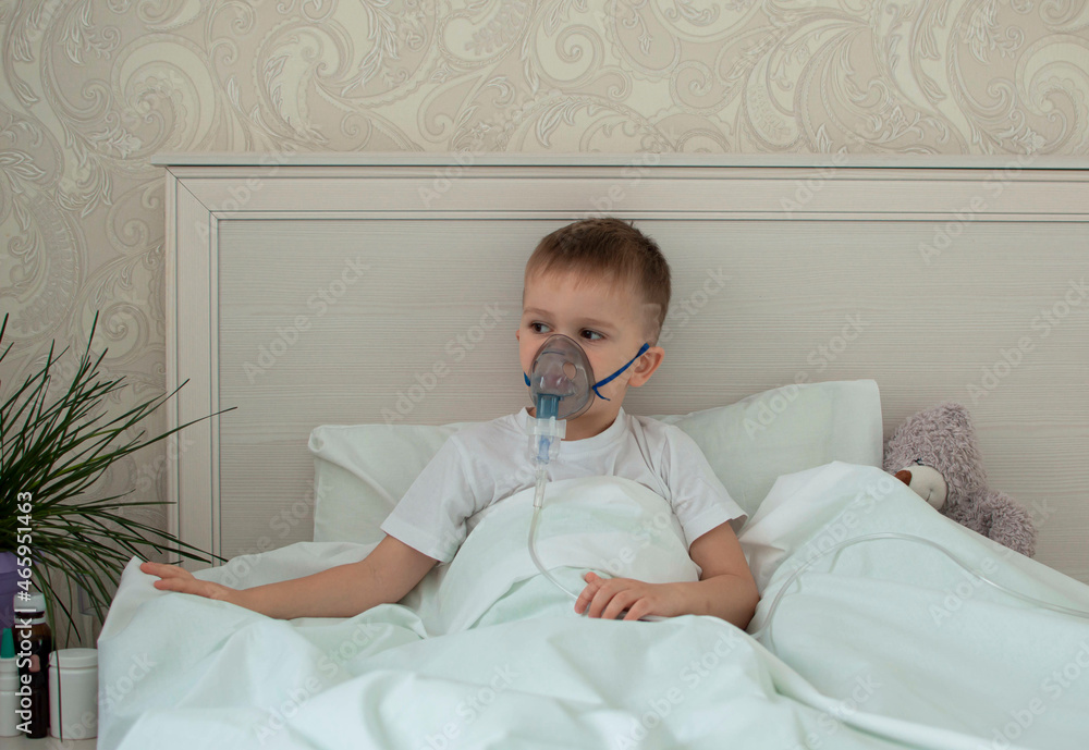 Sick child is sick at home, lying in bed with teddy bear. Does the ...