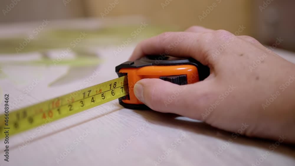 Female Hand Presses Button of an Orange Metallic Inch Tape with a ...