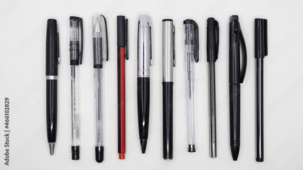 horizontal shot of a group of different types of black pens arranged ...