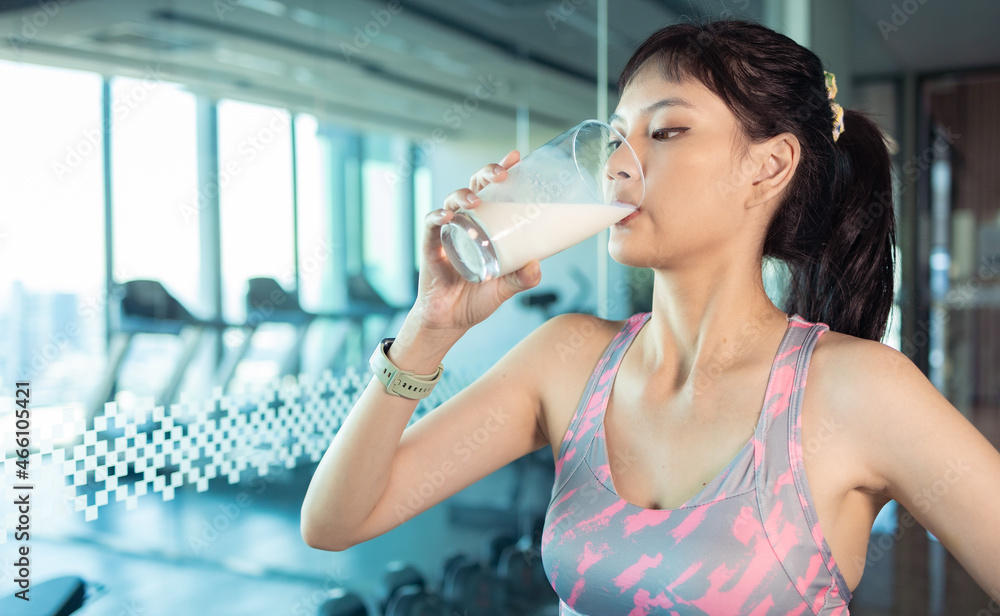 Foto de Attractive fitness asian woman finishing workout and drinking ...