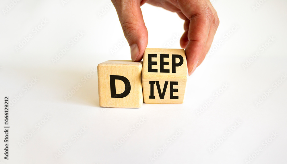 Deep dive symbol. Businessman turns a wooden cube with words 'Deep dive ...