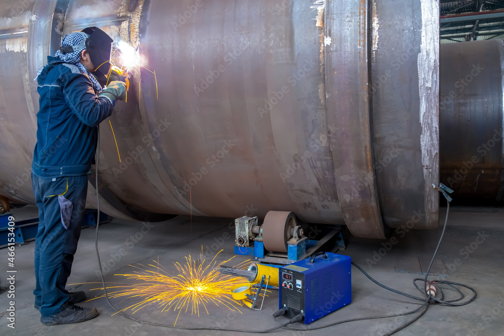 Foto de MMA welding. A welder welds large diameter pipes with manual ...