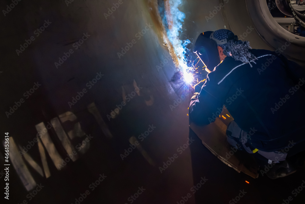 Foto de MMA welding. A welder welds large diameter pipes with manual ...