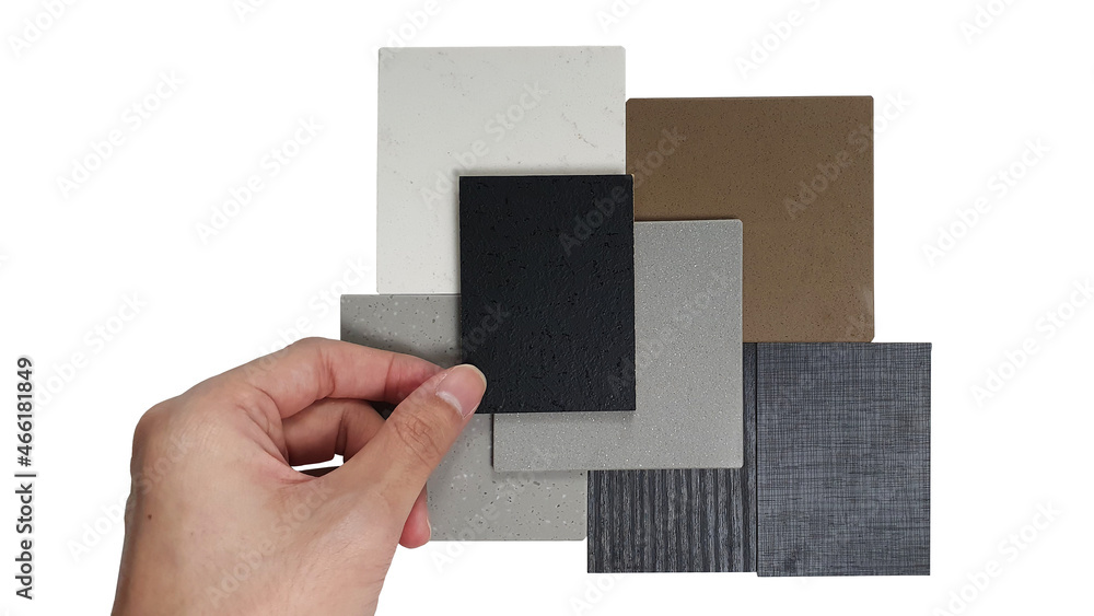 male hand picking material on board showing wooden, fabric, matt ...