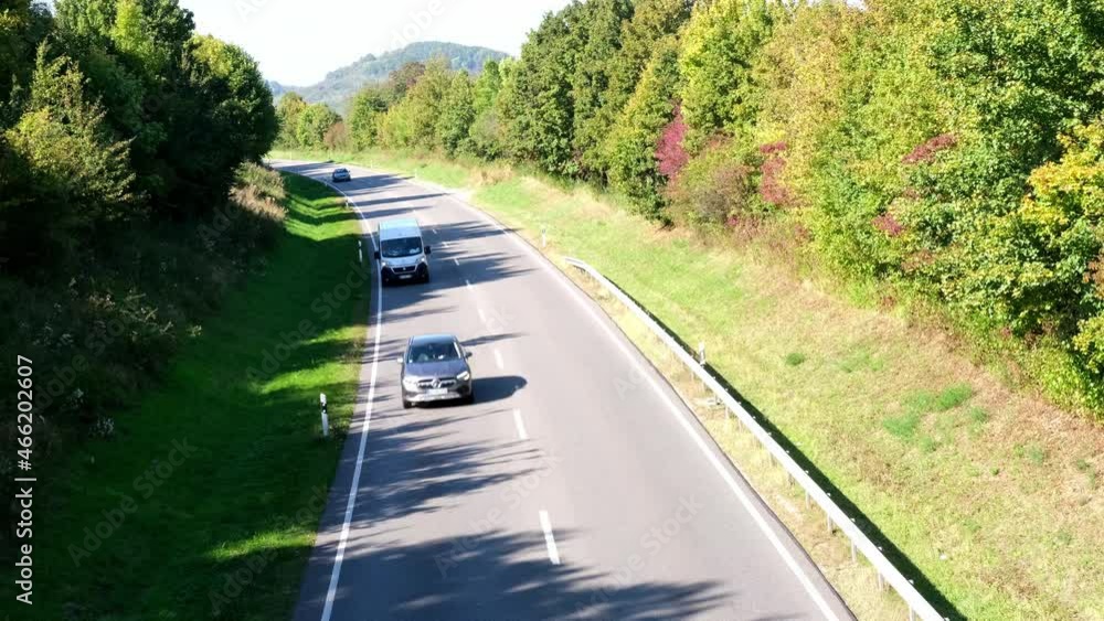 high-speed asphalt road with a white dividing strip goes through a ...