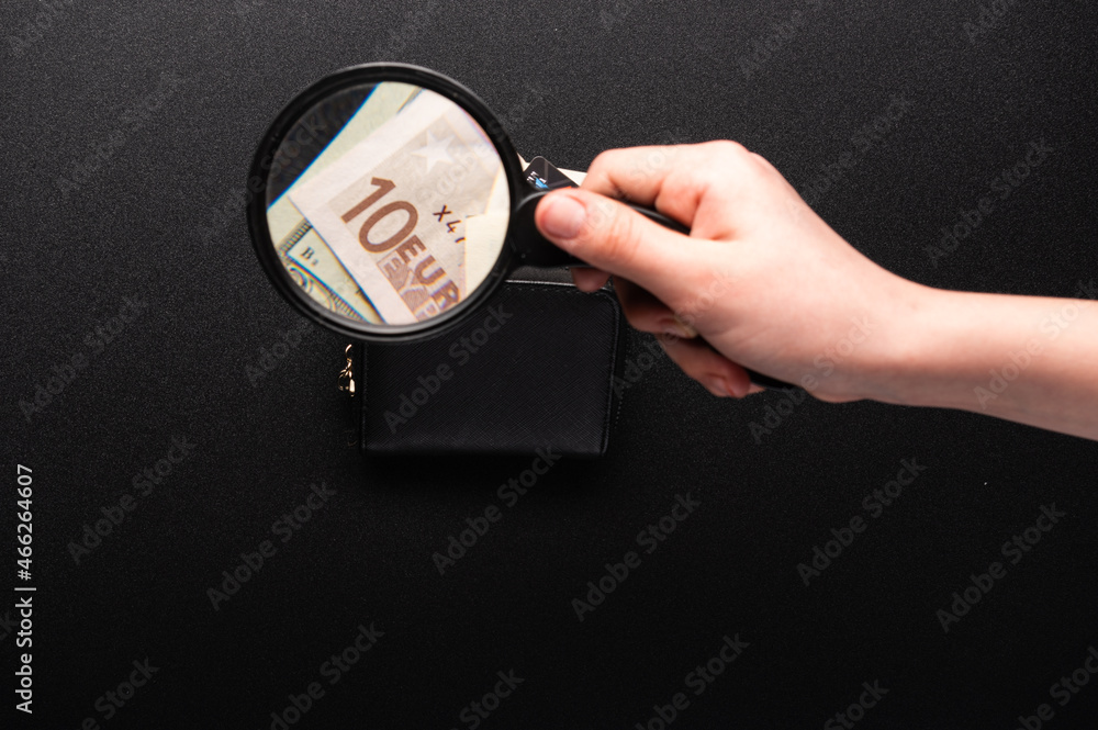 Money under a magnifying glass. Examining money through a magnifying ...