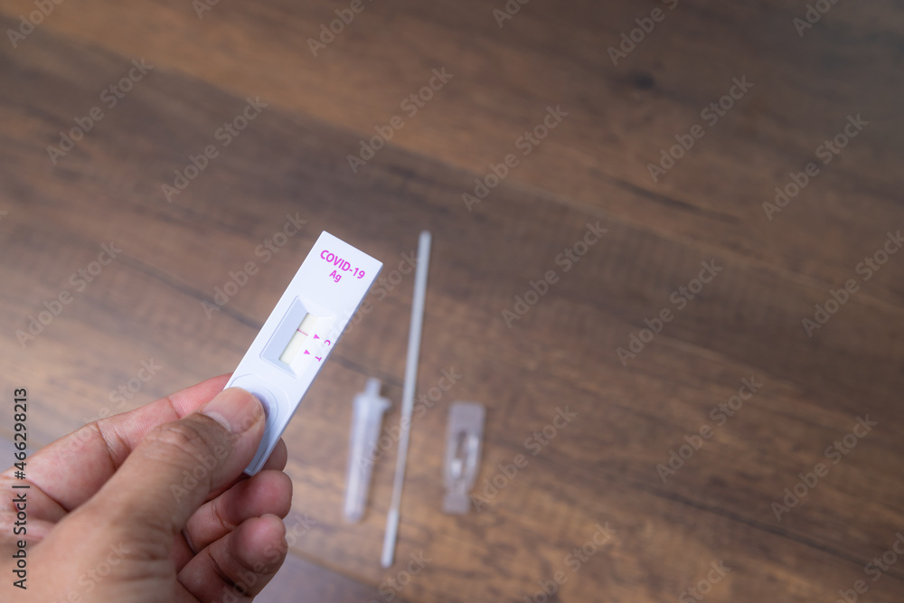 Rapid kits of Covid-19 Ag test or ATK seen on wooden and health mask ...