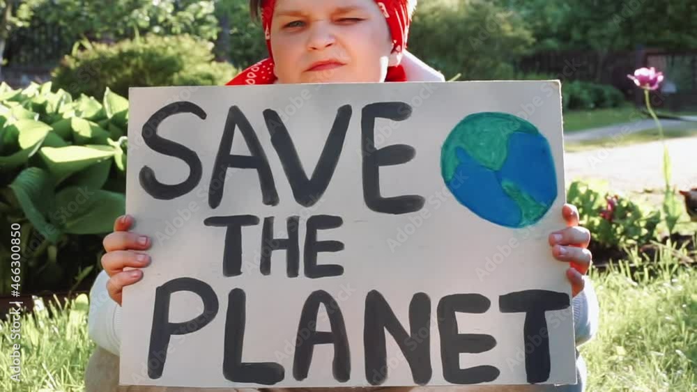 Young kid child holding in hands green posters at global climate strike ...