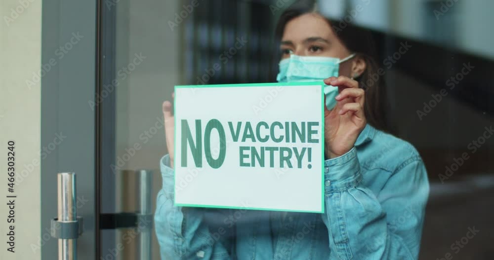 Sad depressed woman wearing face mask attaching sign on the glass in ...