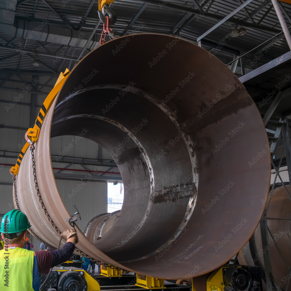 Moving pipes inside the workshop with an overhead crane using a ...