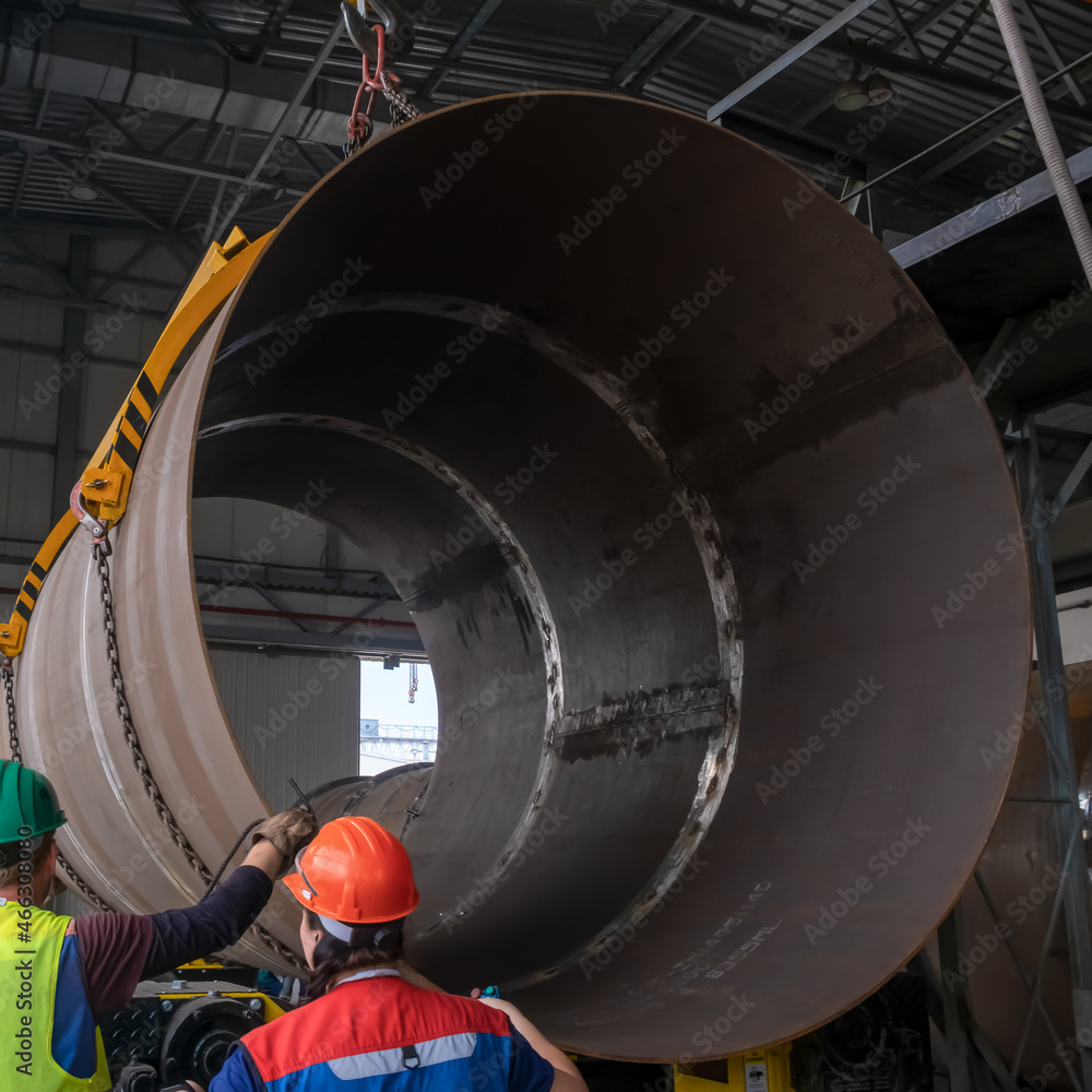 Moving pipes inside the workshop with an overhead crane using a ...