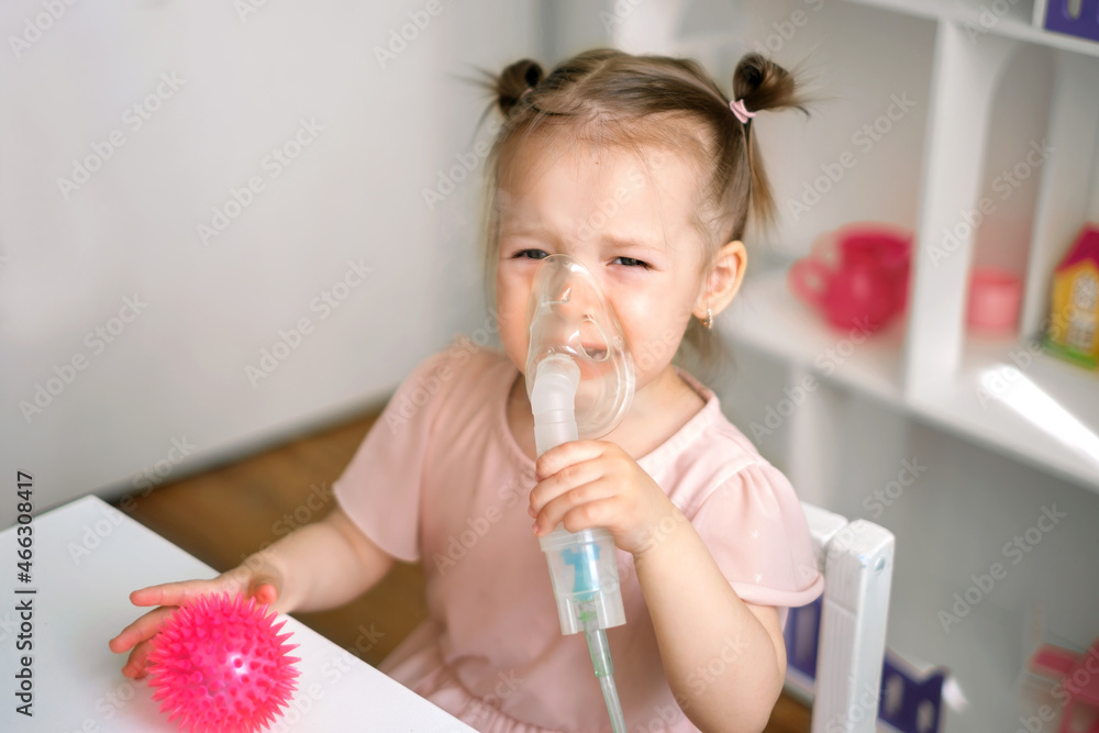 A baby holds a breathing mask and cries while Inhalations. Children's ...