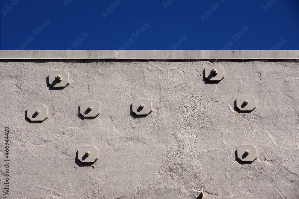 Old building wall with ends of steel rods and plates retrofitted for ...