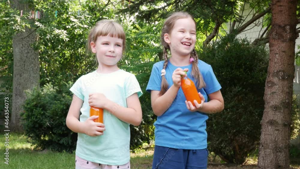 Two children, sisters, siblings, kids holding glass bottles full of ...