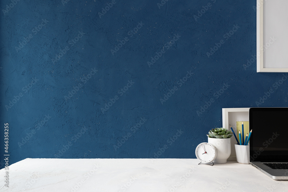 Desk with blue wall and white table mock up.. Stock Photo | Adobe Stock