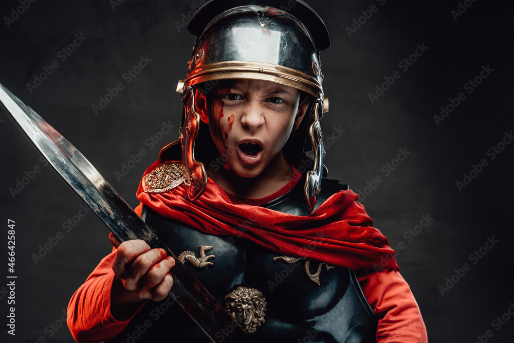 Screaming roman boy warrior holding a sword in dark background Stock ...