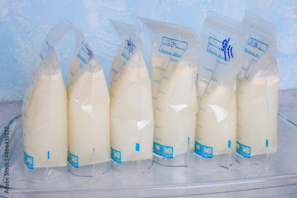 Bags with breast milk on blue background. Milk bank. Expressing breast ...