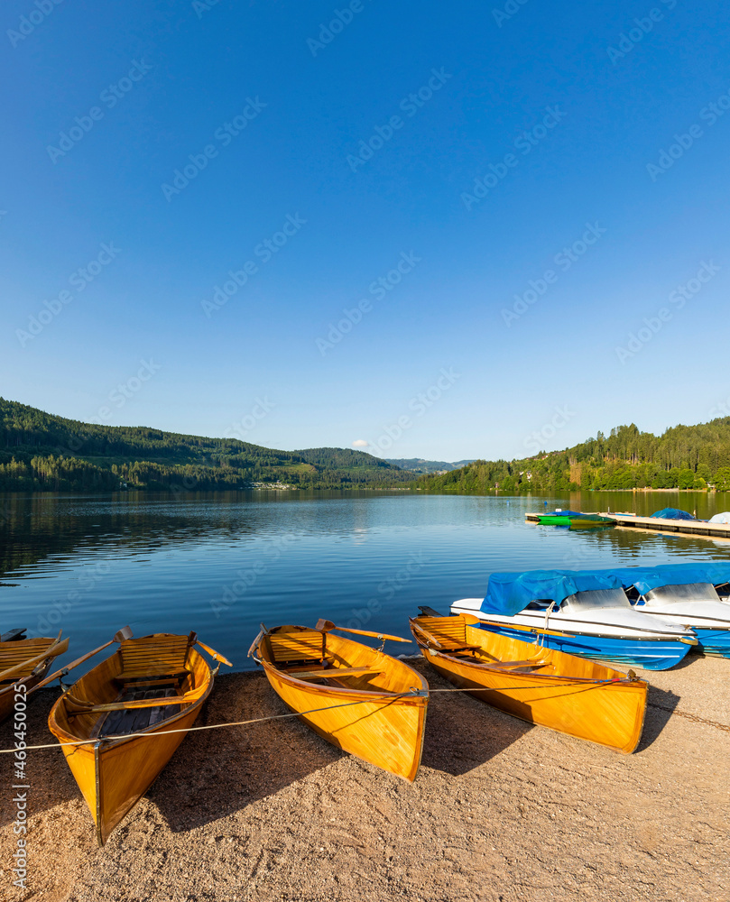 Clear sky over rowboats left on shore of Titisee lake Stock Photo | Adobe Stock