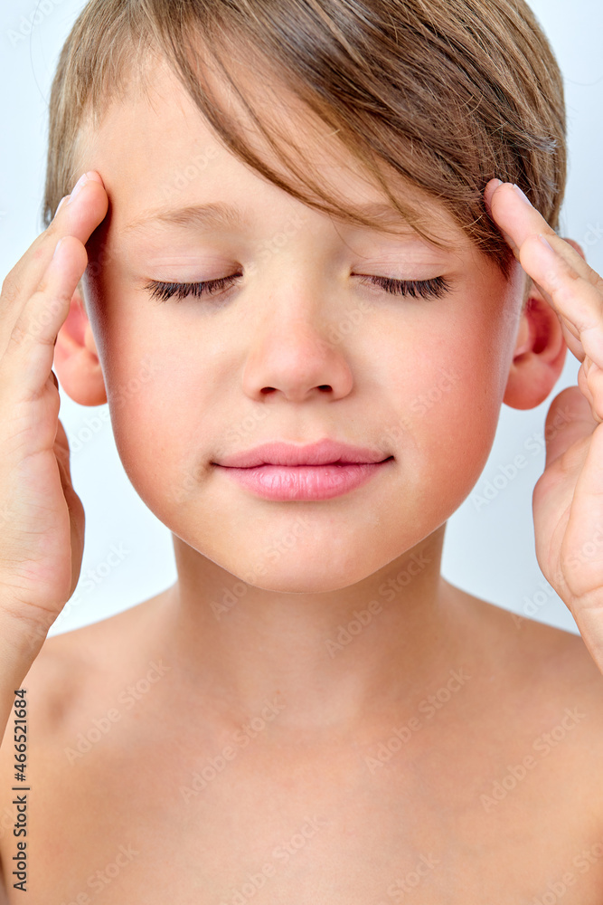 Close-up portrait of boy keeping eyes closed, concentrated on thoughts ...
