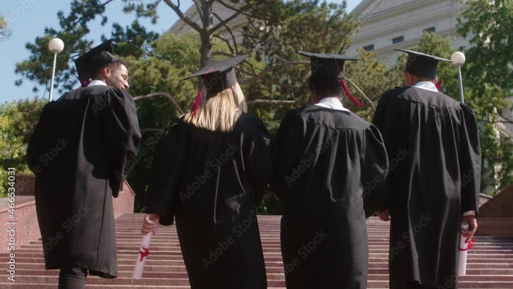 Happy group of multiracial students graduates with graduation caps ...