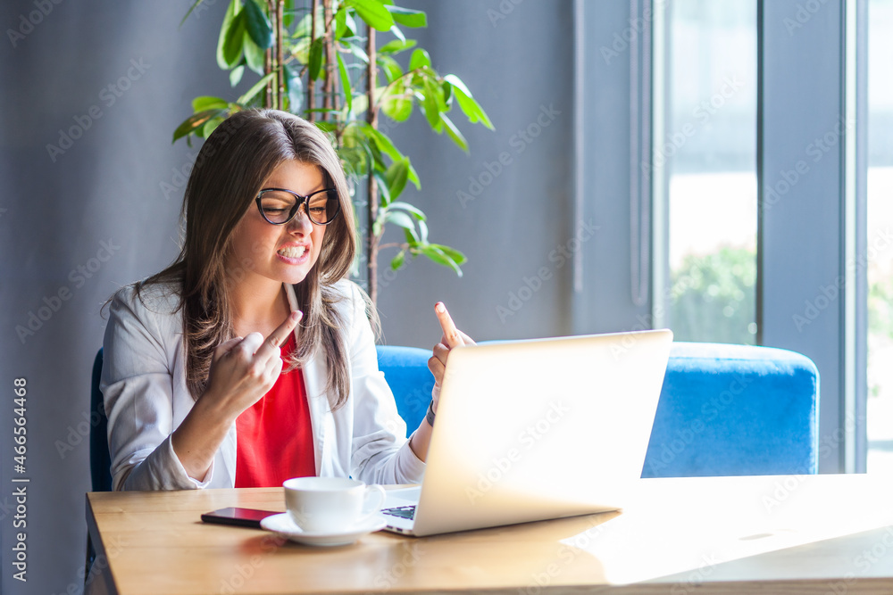 Rude woman employee in glasses showing middle finger to laptop screen ...