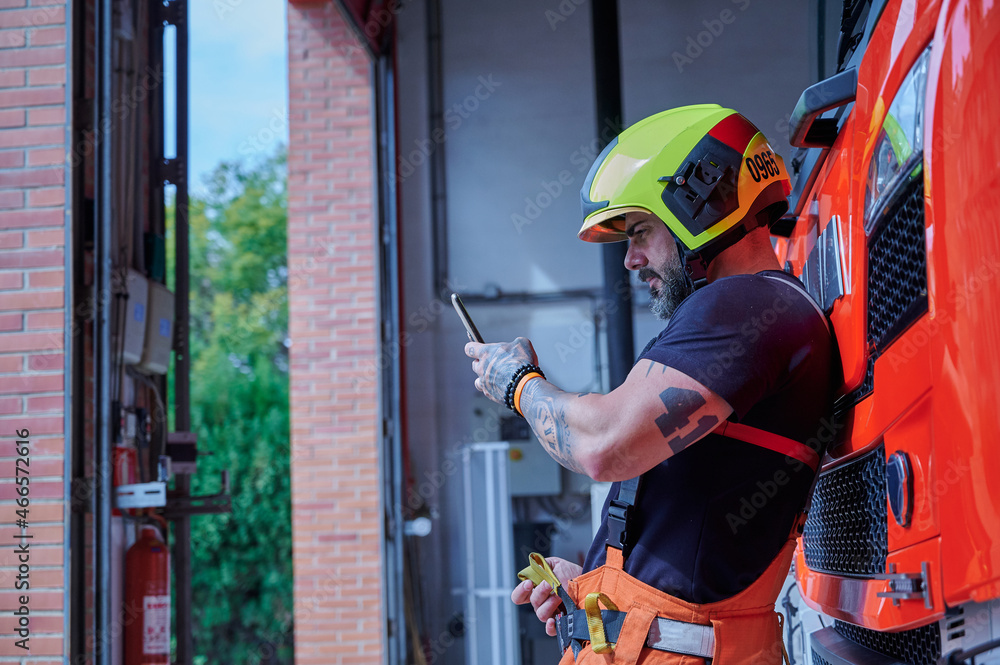Firefighter connected and interacting with the smartphone on the fire ...