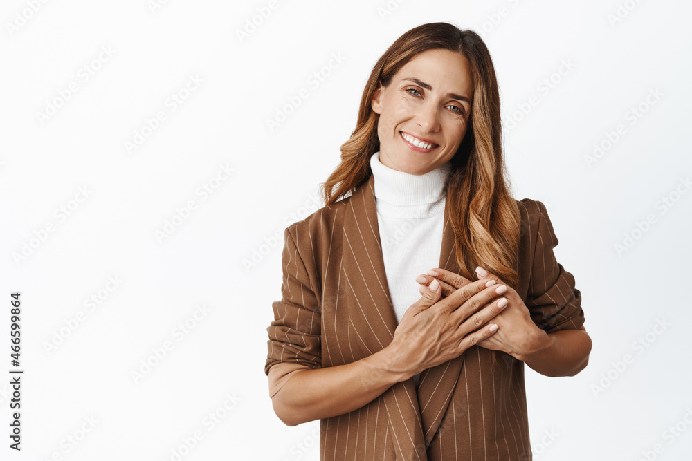Portrait of corporate woman smiling, holding hands on heart and looking ...