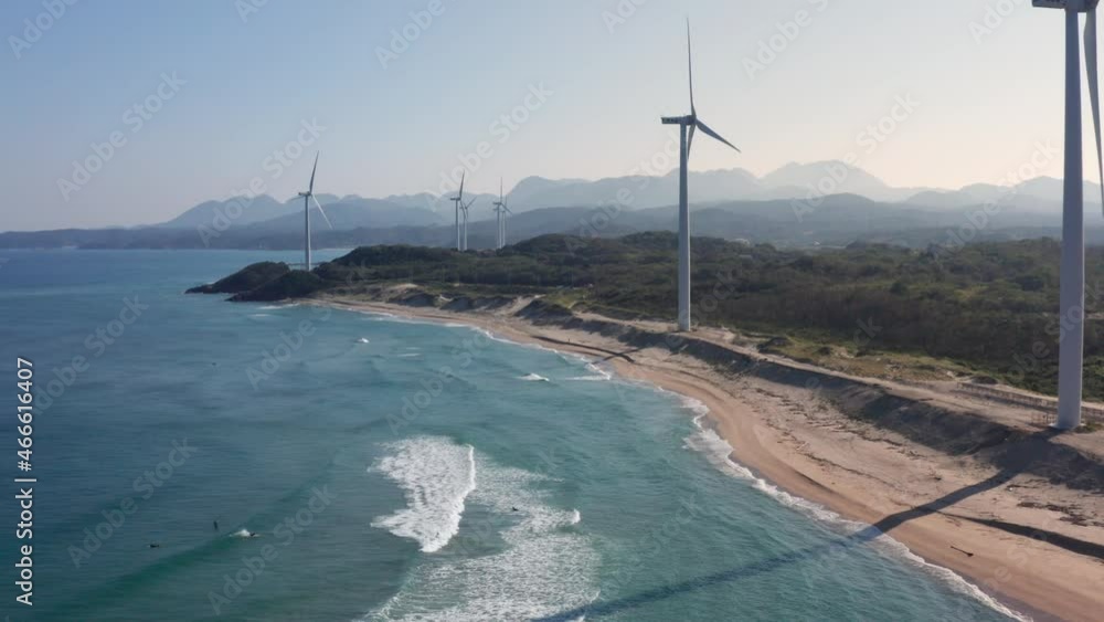 Coastal wind farm in Japan, with waves and surfers. renewable energy ...