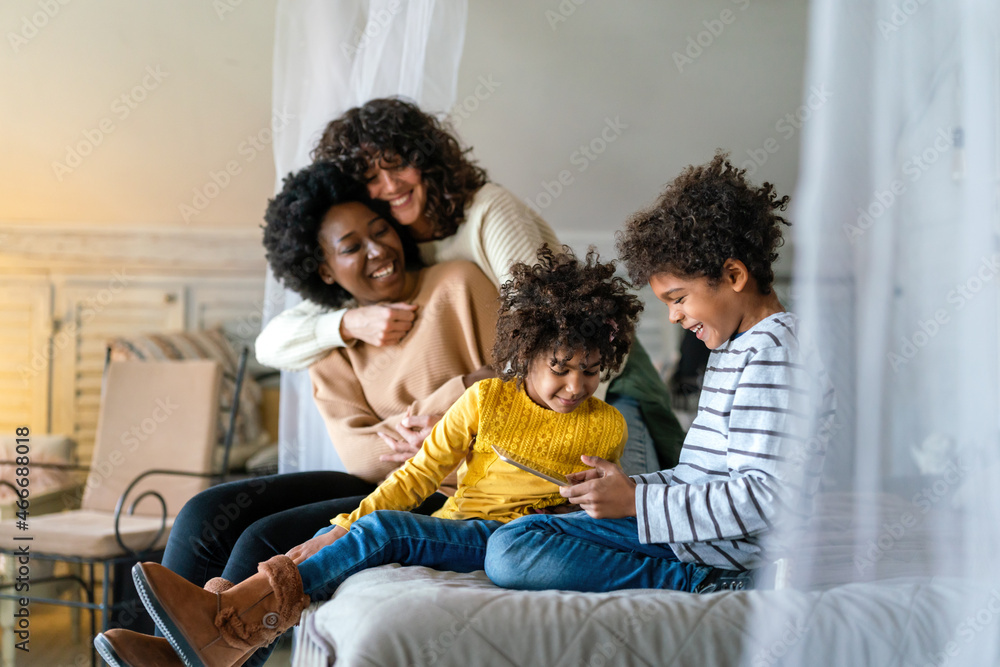 Happy lesbian multiethnic couple in love with childen at home. Family ...