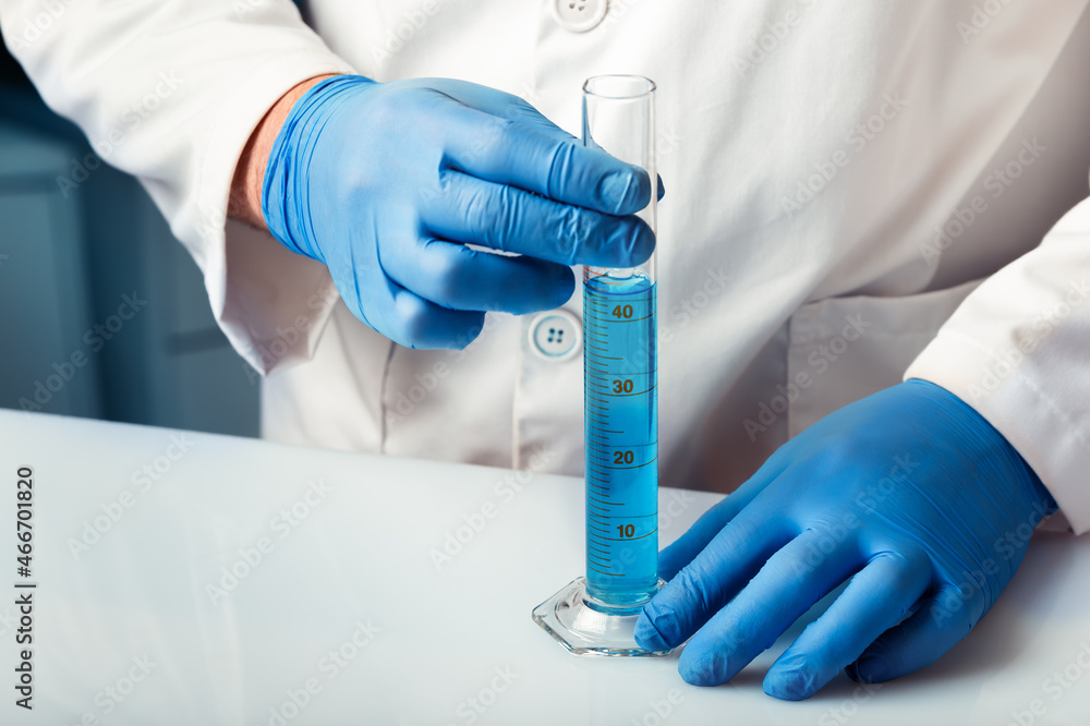 Scientist working whit test tube graduated cylinder analyzing fluids in ...