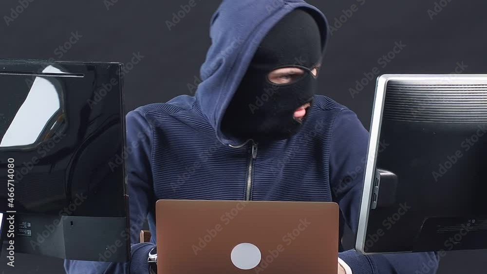 Serious hacker male sit at table, look at screen of laptop studying ...