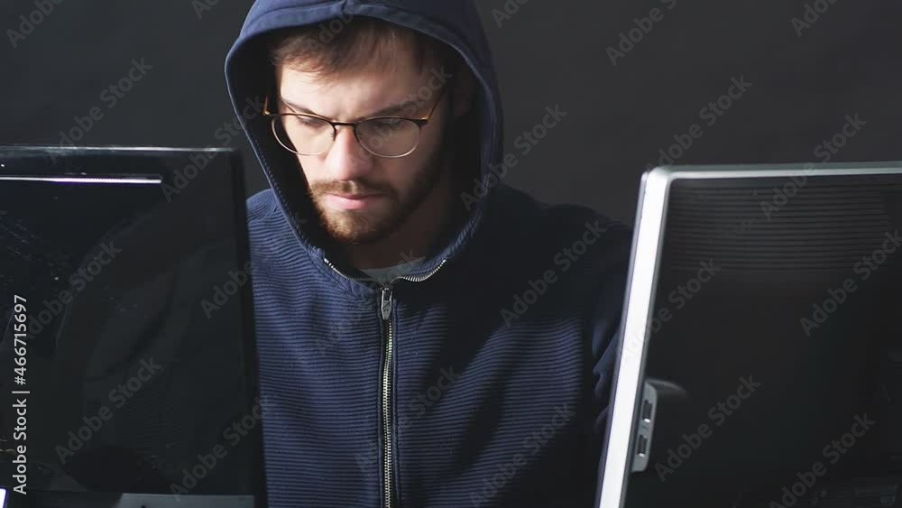 Serious caucasian hacker male look at screen of laptop studying ...