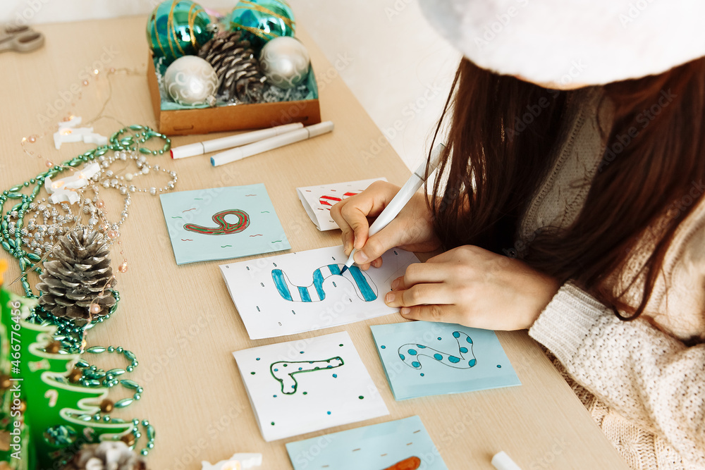 a child makes a Christmas advent calendar out of paper with his own ...