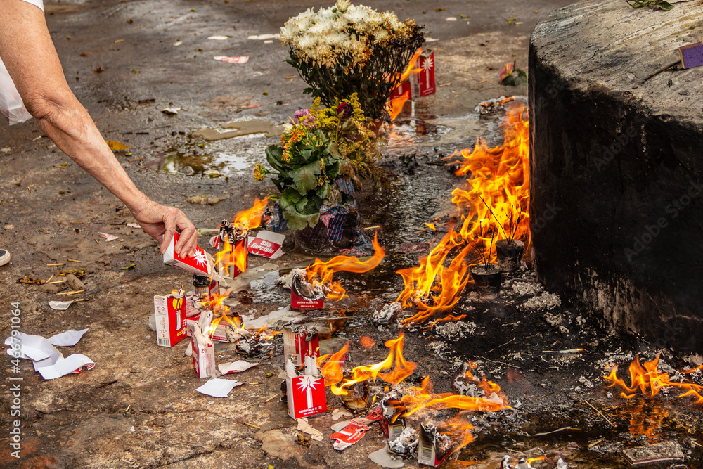 Braço de uma pessoa colocando mais velas para queimar. Cena de um ...