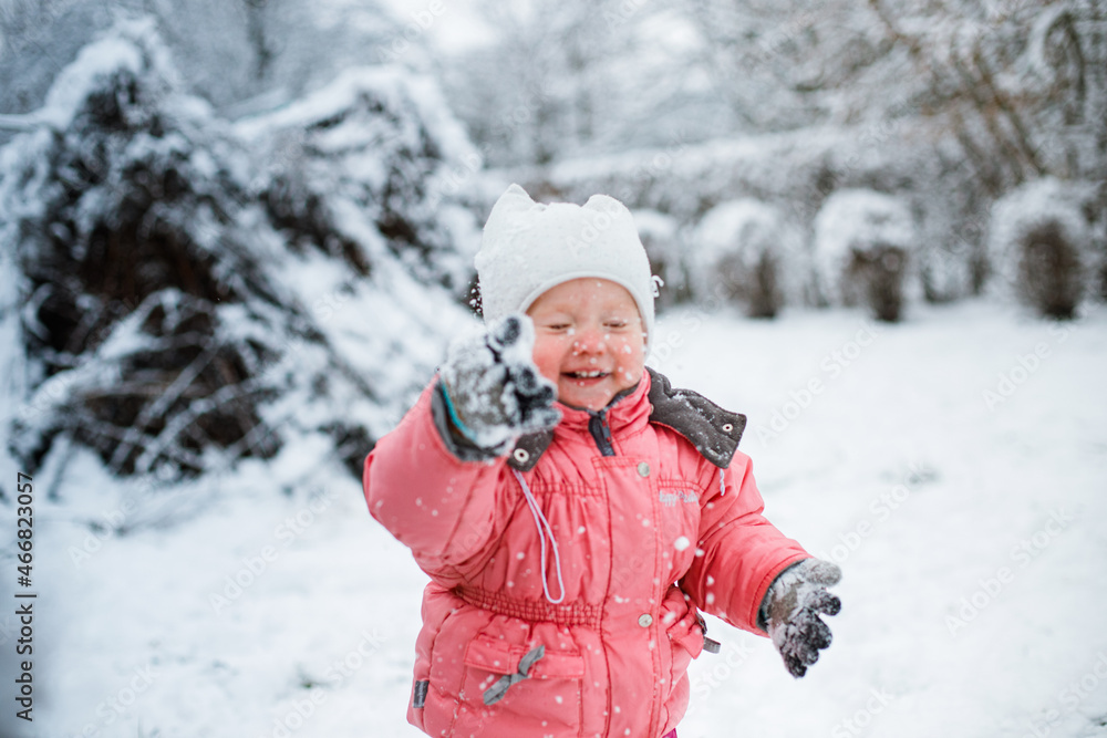 baby threw snowball and closed eyes from snow that got in face. Walking ...