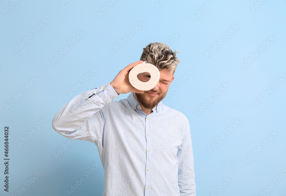 Young man with toilet paper on color background Stock Photo | Adobe Stock
