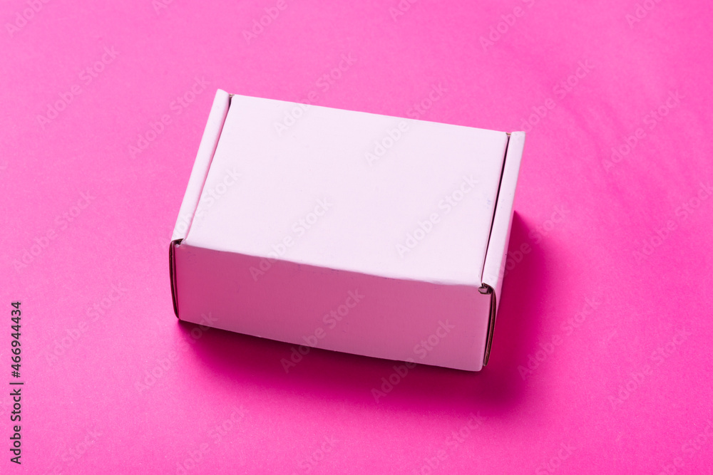 Simple pink cardboard box on color background, opened, empty inside ...