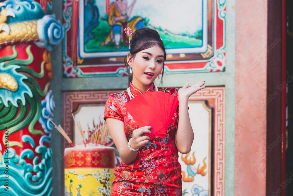 Chinese woman in a red cheongsam (qipao) dress holding red envelopes ...