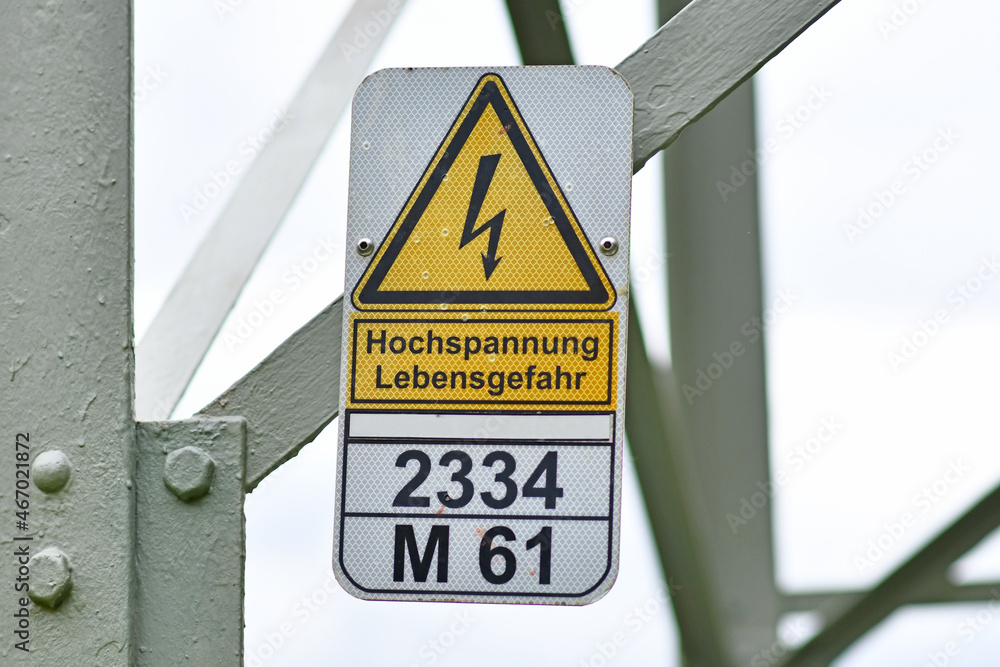 High voltage warning sign at electric transmission tower Stock Photo ...