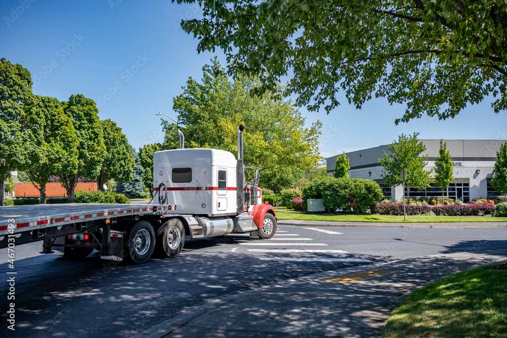 Classic powerful big rig semi truck with empty flat bed semi trailer ...