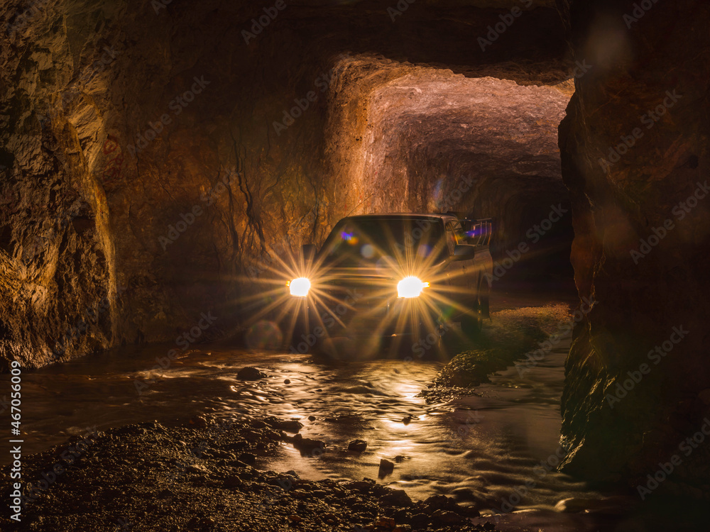 Foto de car lights and flare inside deep old mining tunnel cave with ...