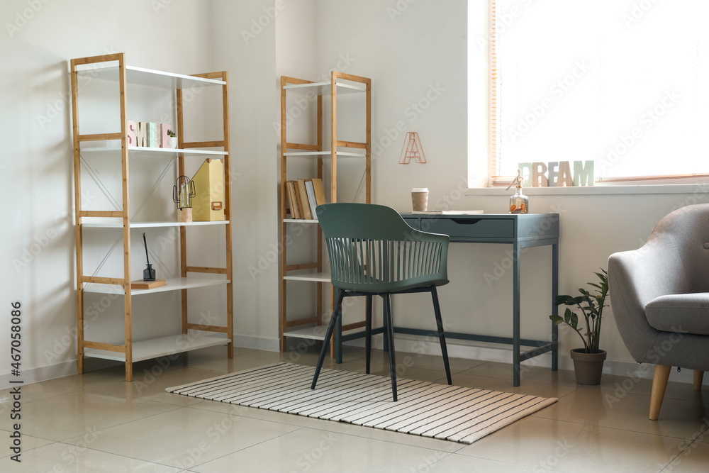Interior of room with modern workplace, shelf units and armchair Stock ...