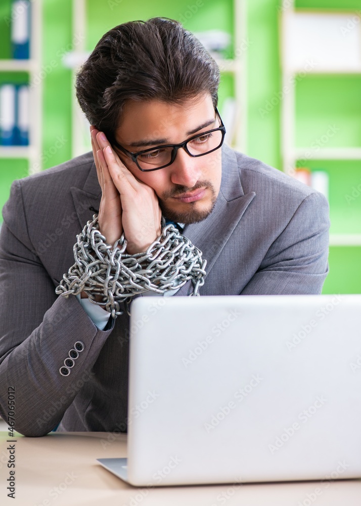 Employee chained to his desk due to workload Stock Photo | Adobe Stock