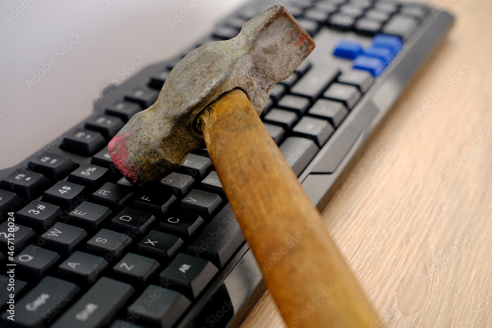 closeup computer keyboard, iron hammer hits keys with force, breaks ...