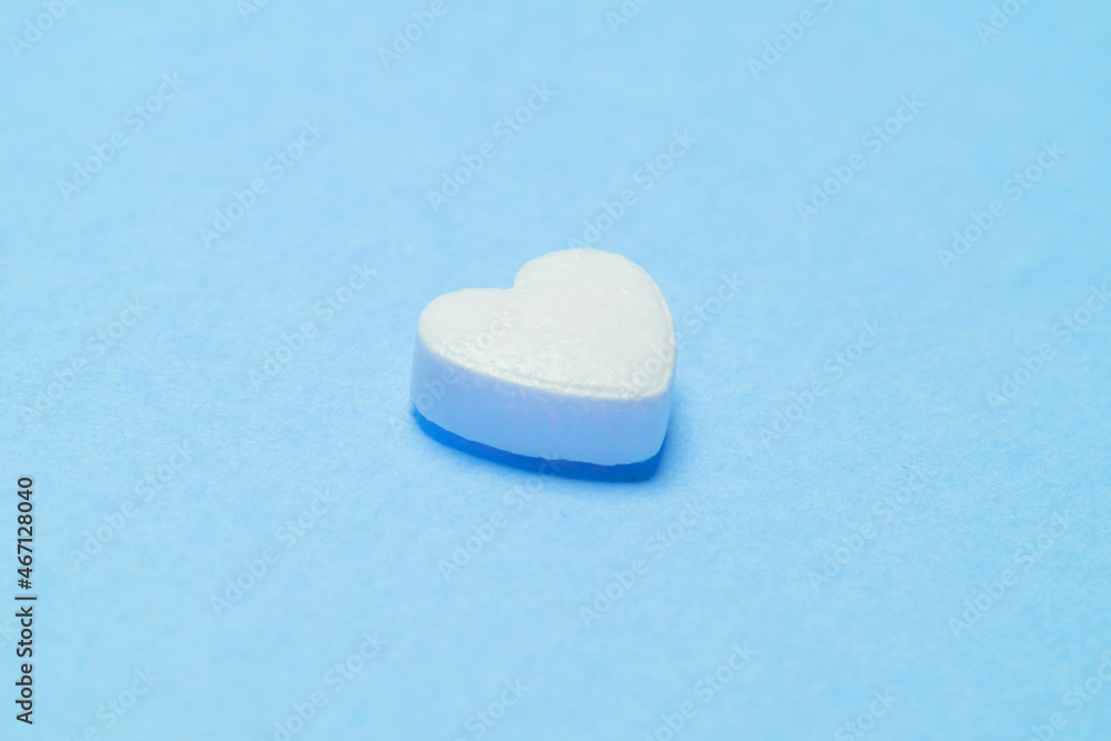 Heart shaped pill on a blue background. Medicines for the heart and for ...