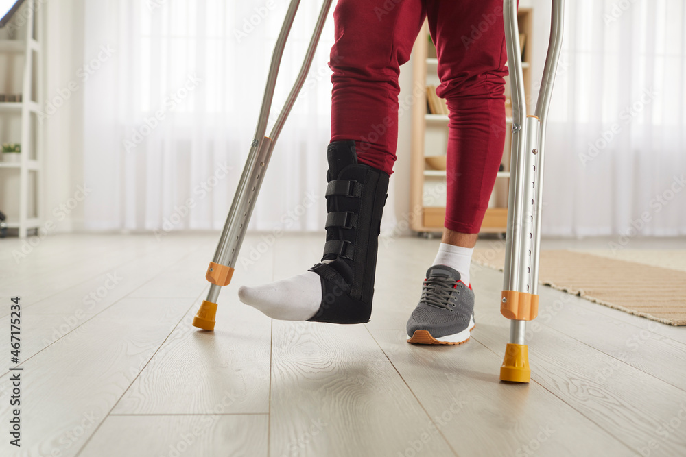 Unrecognizable person with broken leg or foot injury walking on ...