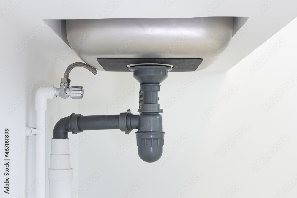 Drain pipe or sewer under kitchen sink. Pvc plastic pipe and flexible ...